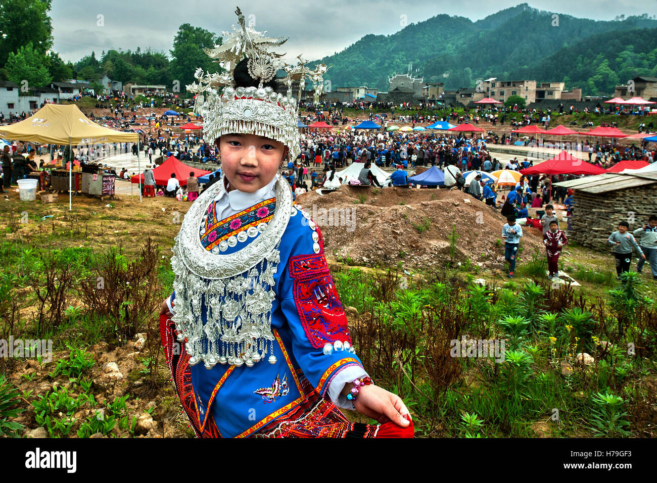 A Miao girl poses in front of the circulare platform, place of the ...