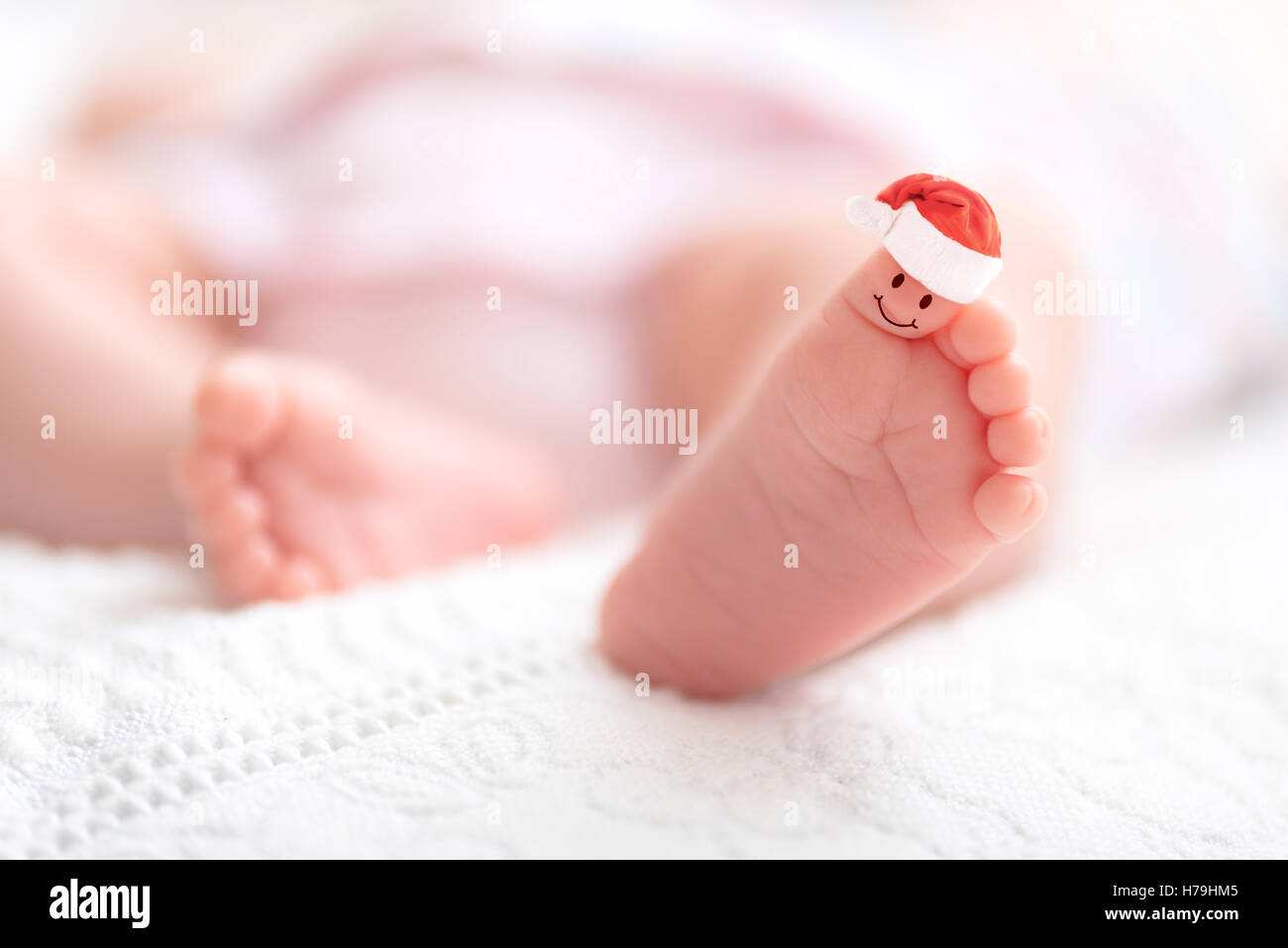 A close-up of tiny baby feet with Santa Claus hat - Merry Christmas ...
