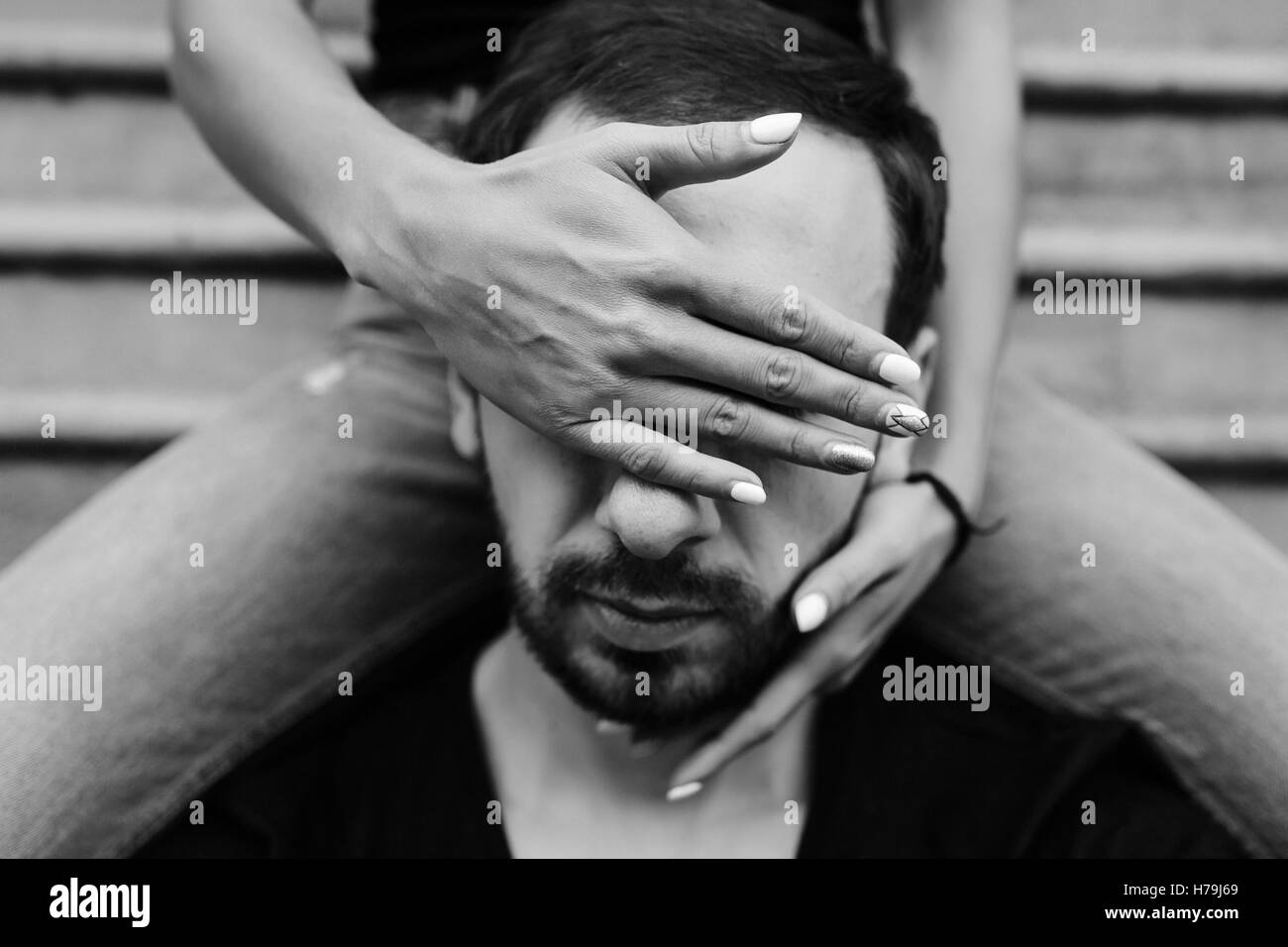 Woman covers man's face Stock Photo - Alamy