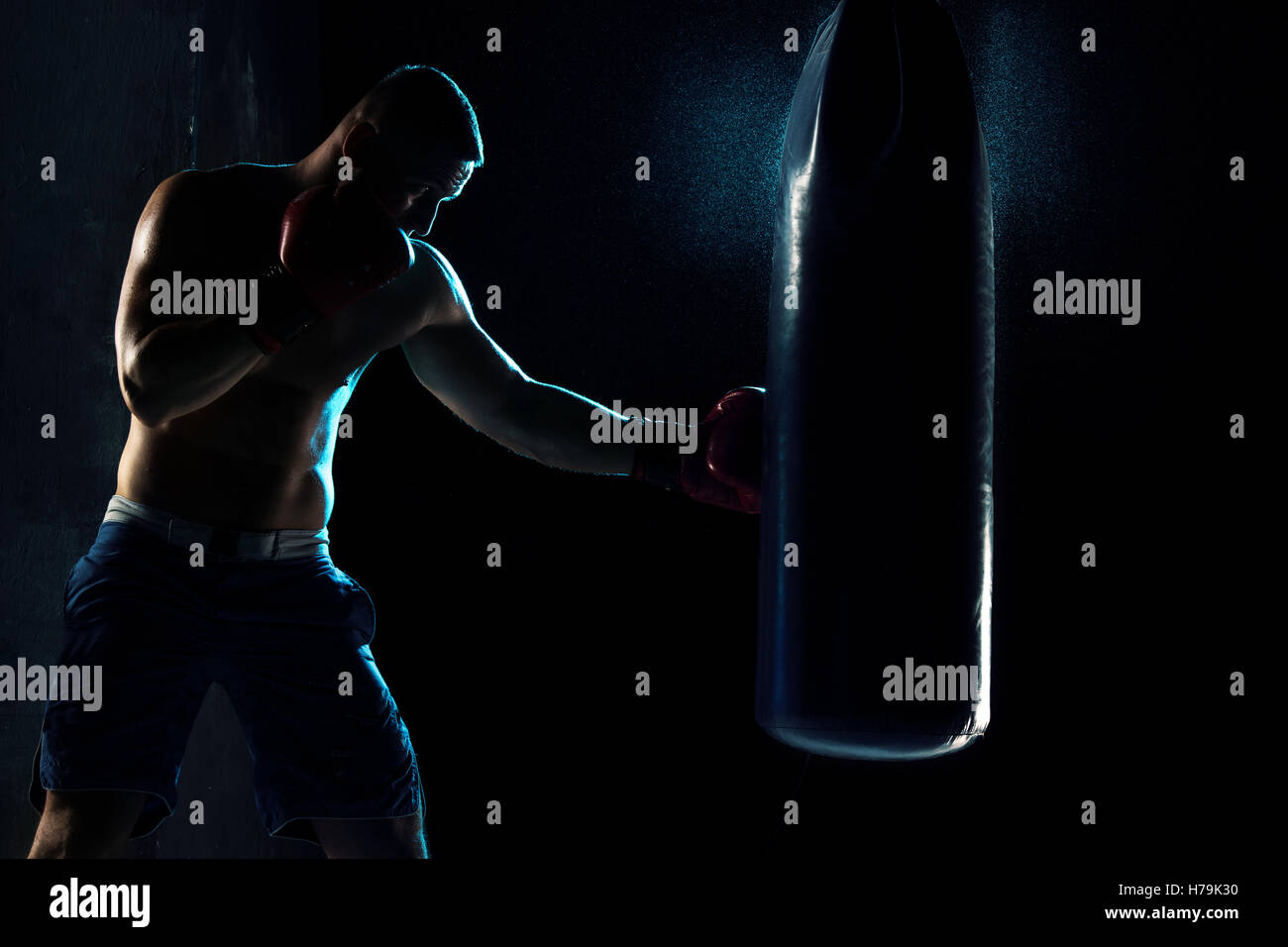 Male boxer boxing in punching bag Stock Photo - Alamy