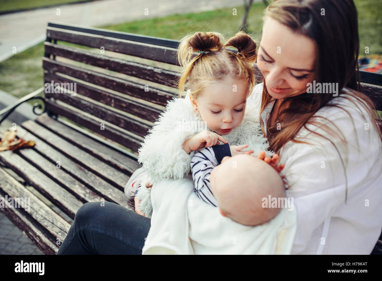 mother and two daughters rest on a bench Stock Photo - Alamy