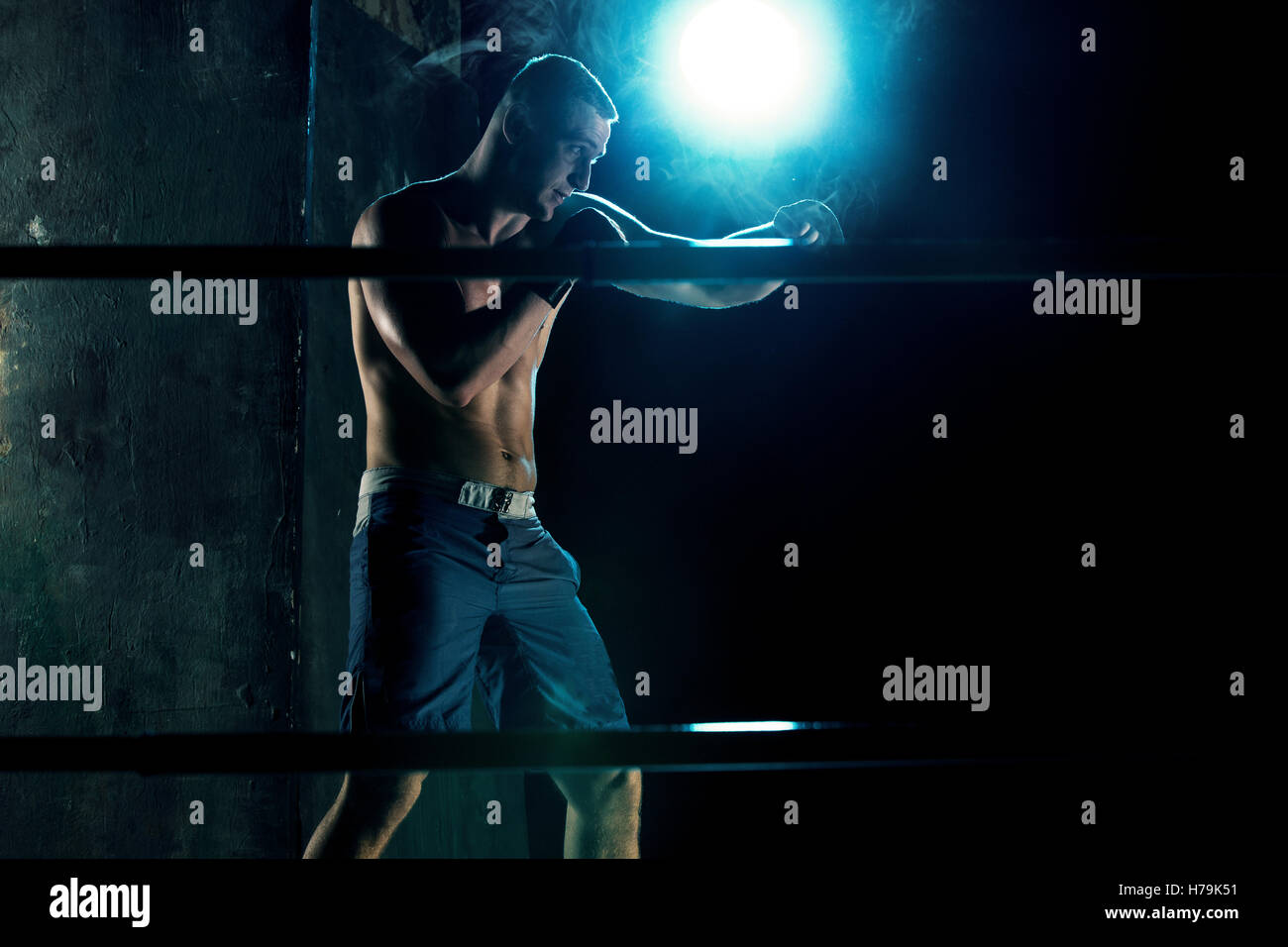 Male boxer boxing in a dark studio Stock Photo - Alamy