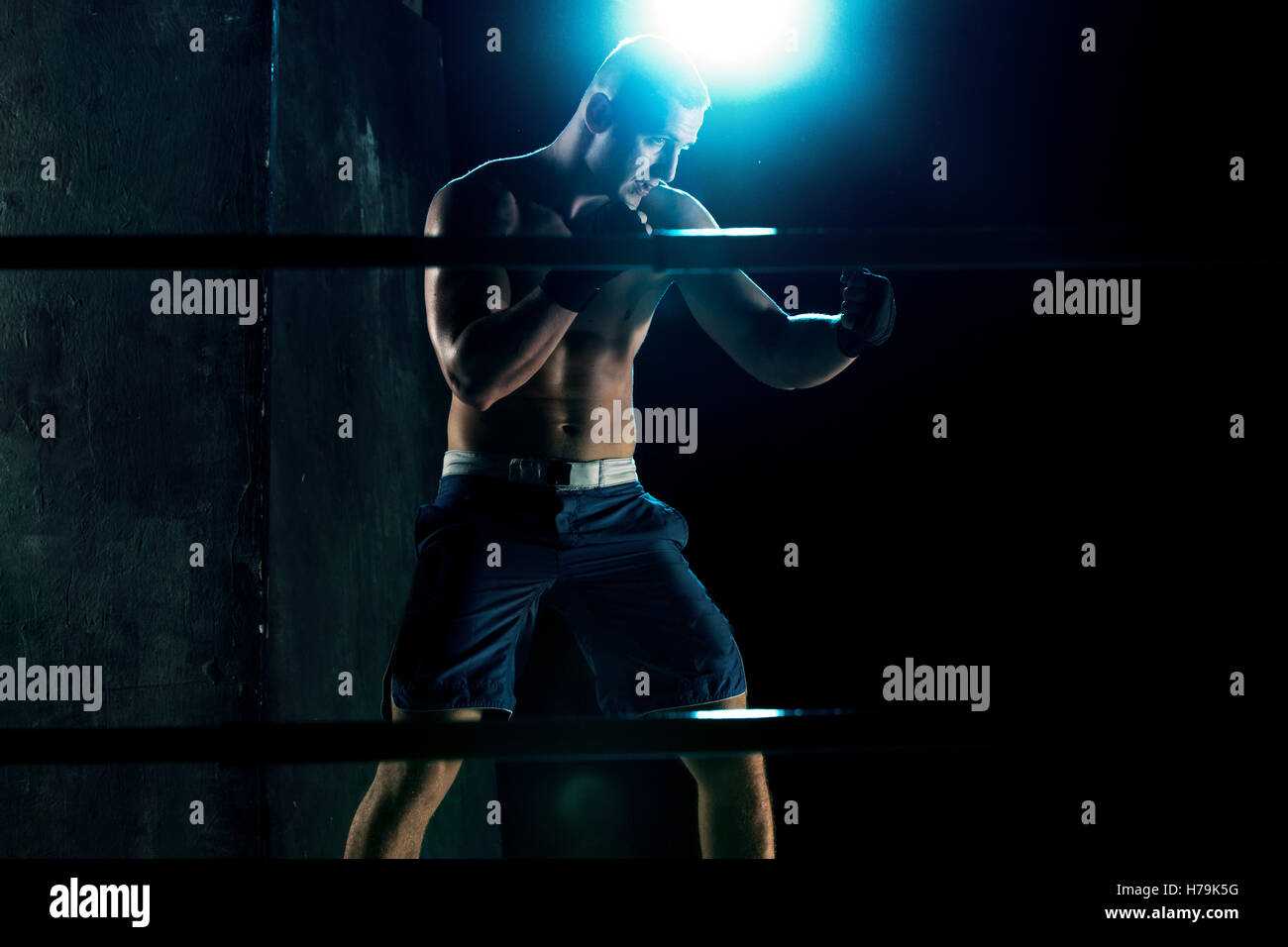 Male boxer boxing in a dark studio Stock Photo - Alamy