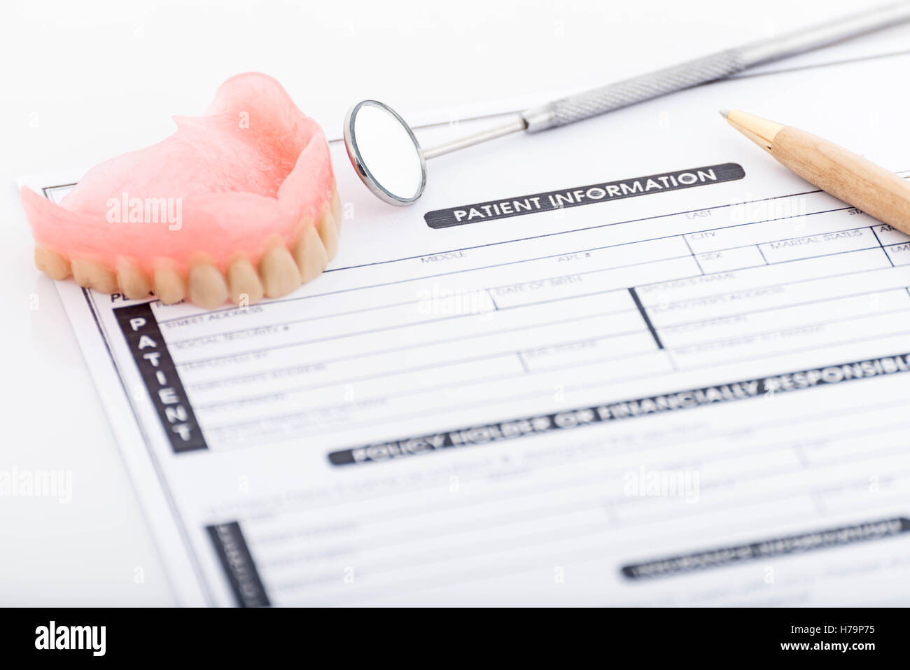Patient information form and dentures with dental glass with pen on ...