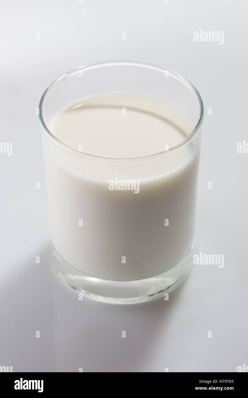 Colorless glass full of cow milk on white background Stock Photo - Alamy