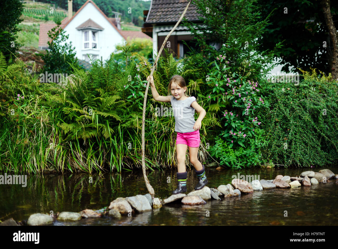 Cute little girl crossing river with cane, children outdoor games Stock ...