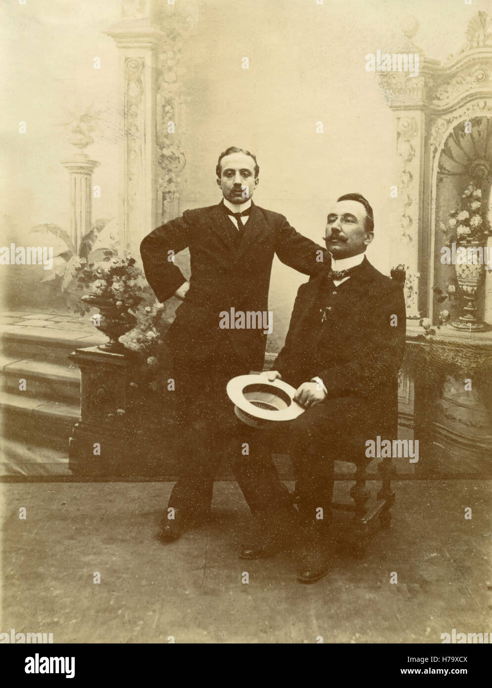 Portrait of two men, one sitting the other standing, Italy Stock Photo ...
