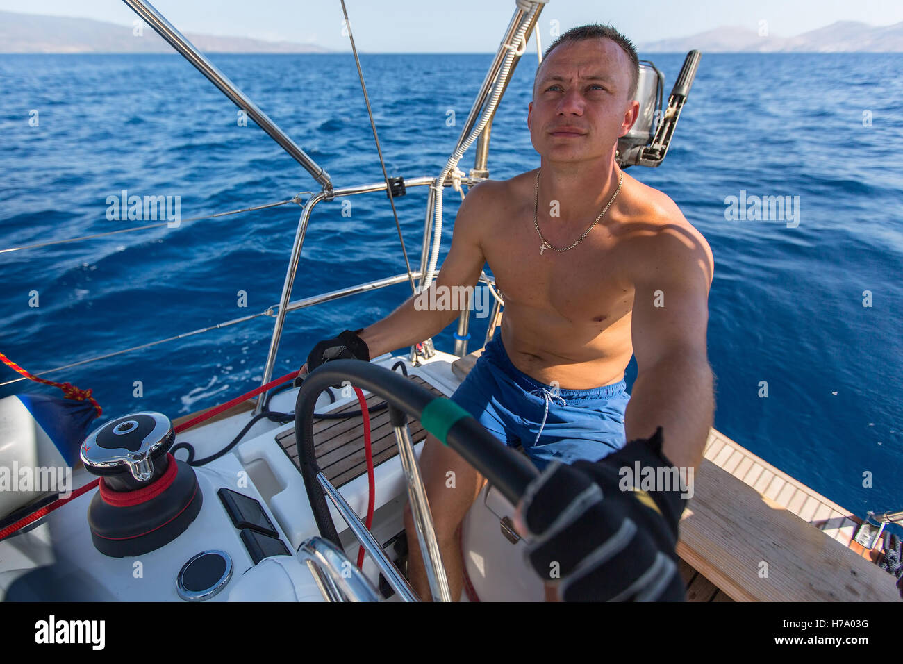 Young man skipper steers boat sailing yacht on the ocean Stock Photo ...
