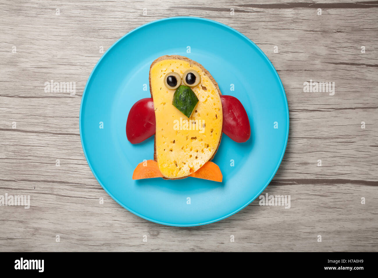 Penguin made of bread and cheese on plate and board Stock Photo - Alamy