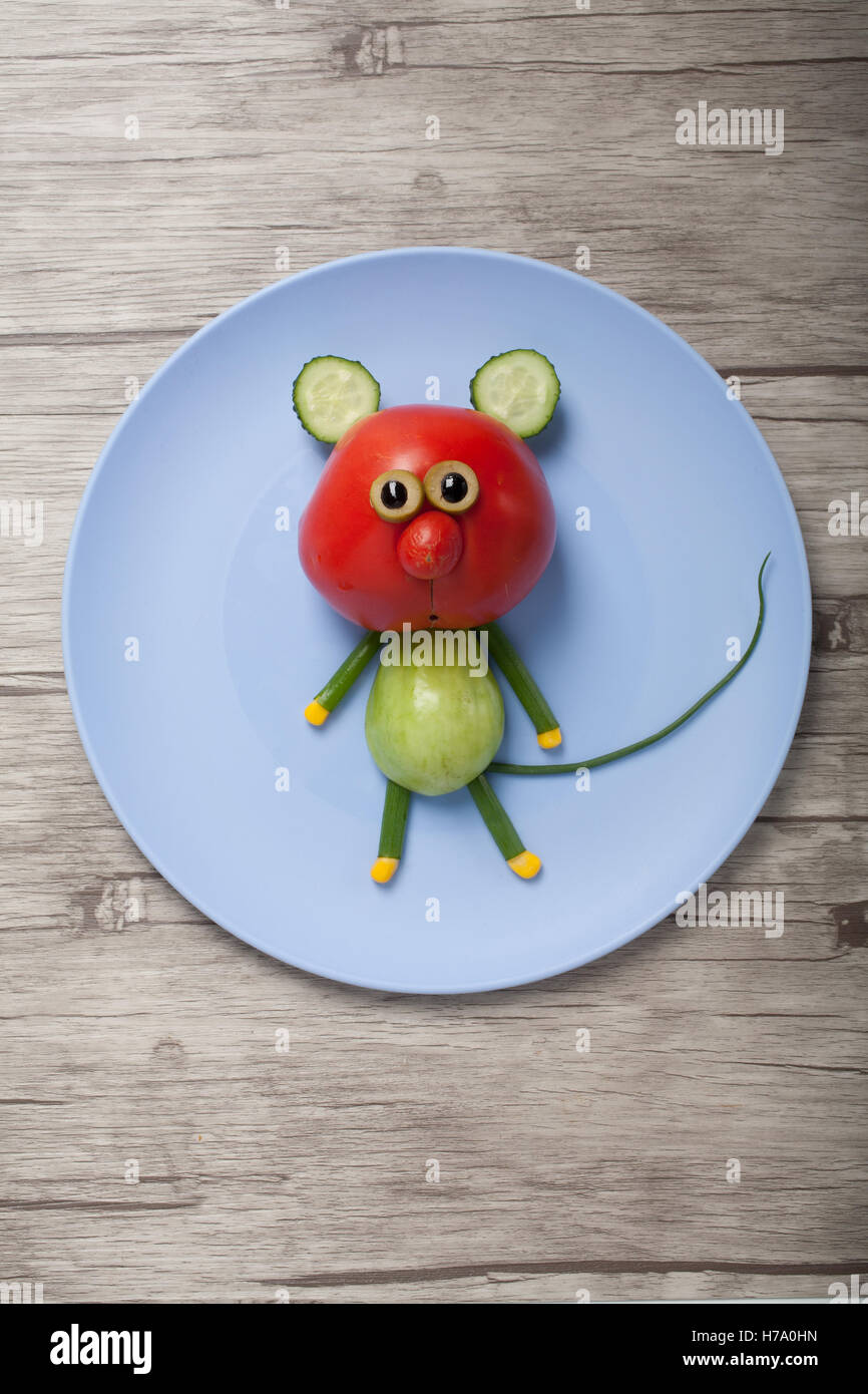Funny mouse made of red and green tomato on plate and desk Stock Photo ...