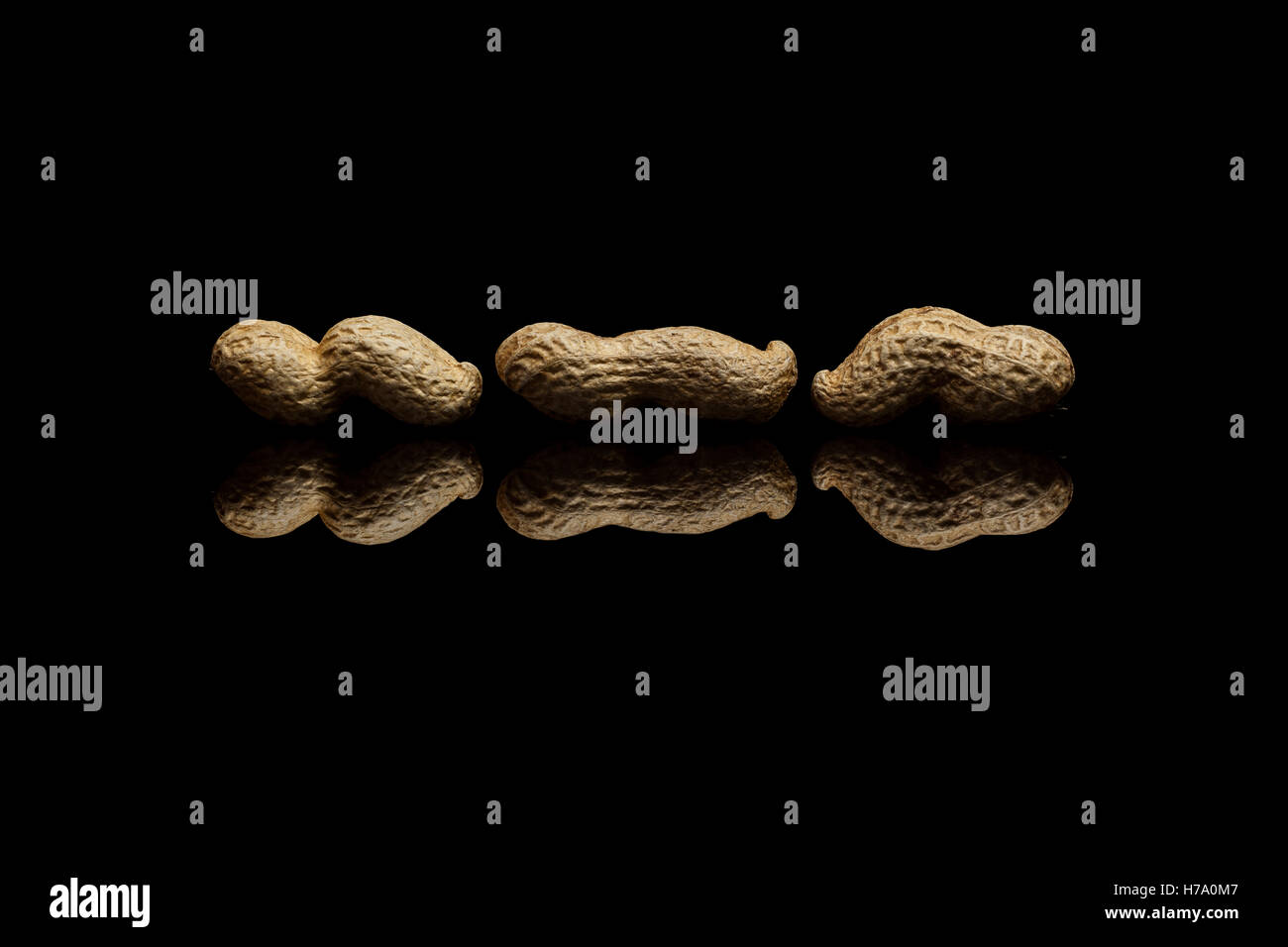 Three whole peanuts isolated on black reflective background Stock Photo ...