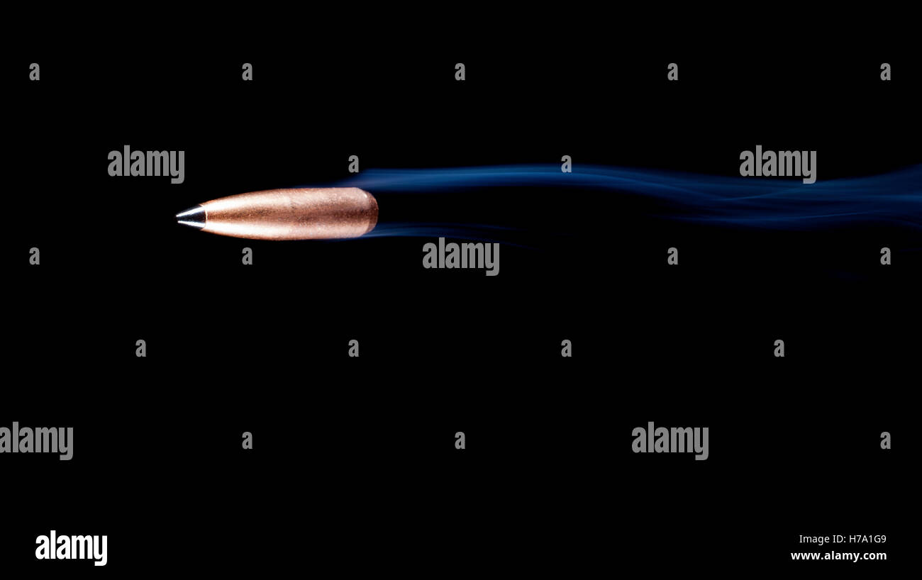 Copper plated bullet with black polymer tip and smoke behind Stock ...