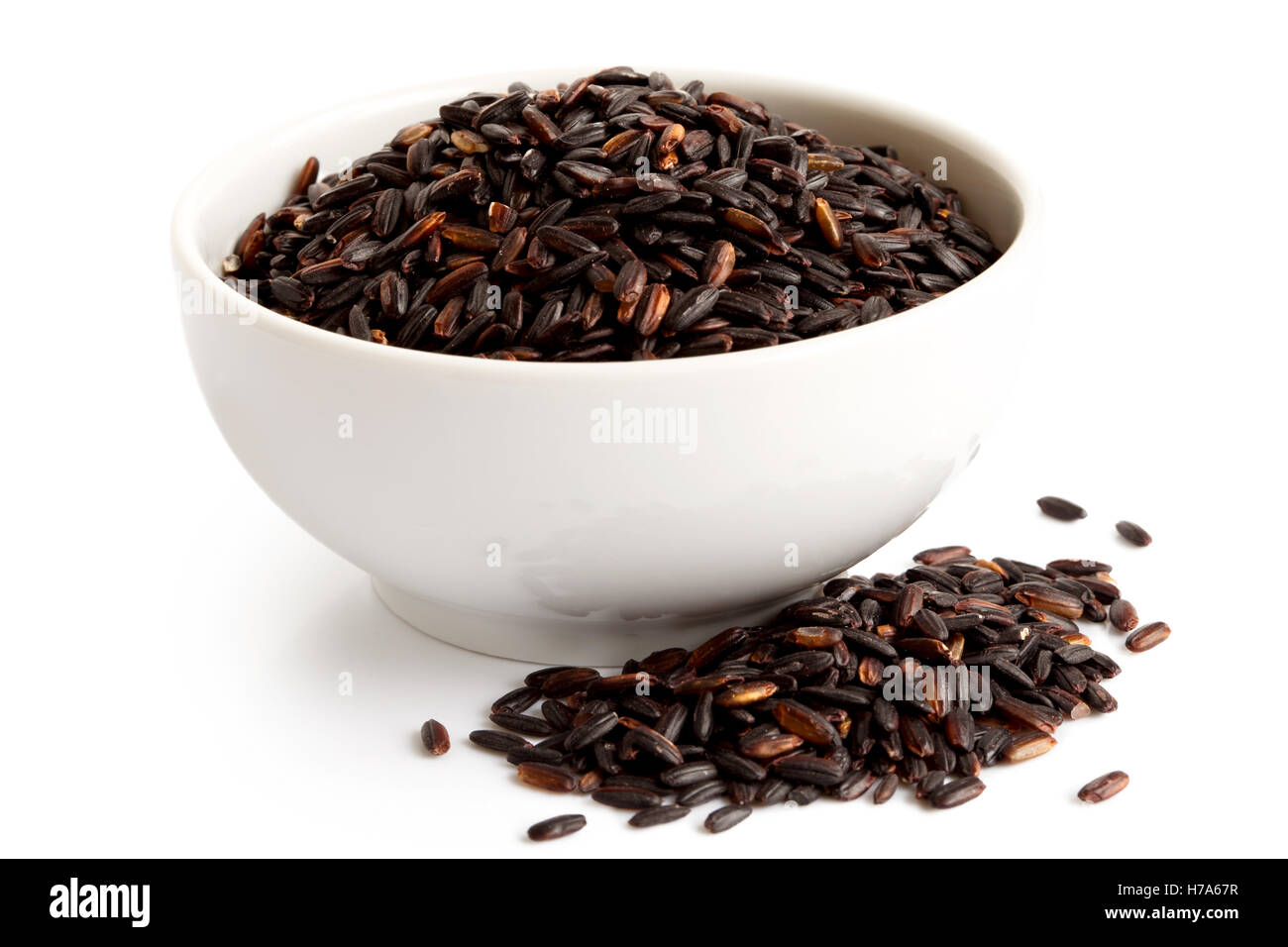 Bowl of Nerone black long grain rice isolated on white. Spilled rice ...