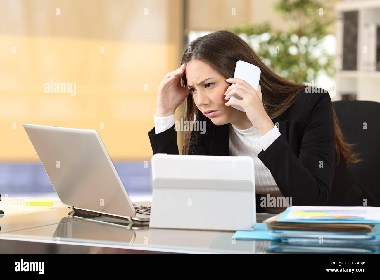 Worried executive talking on the phone trying to solve problems with ...