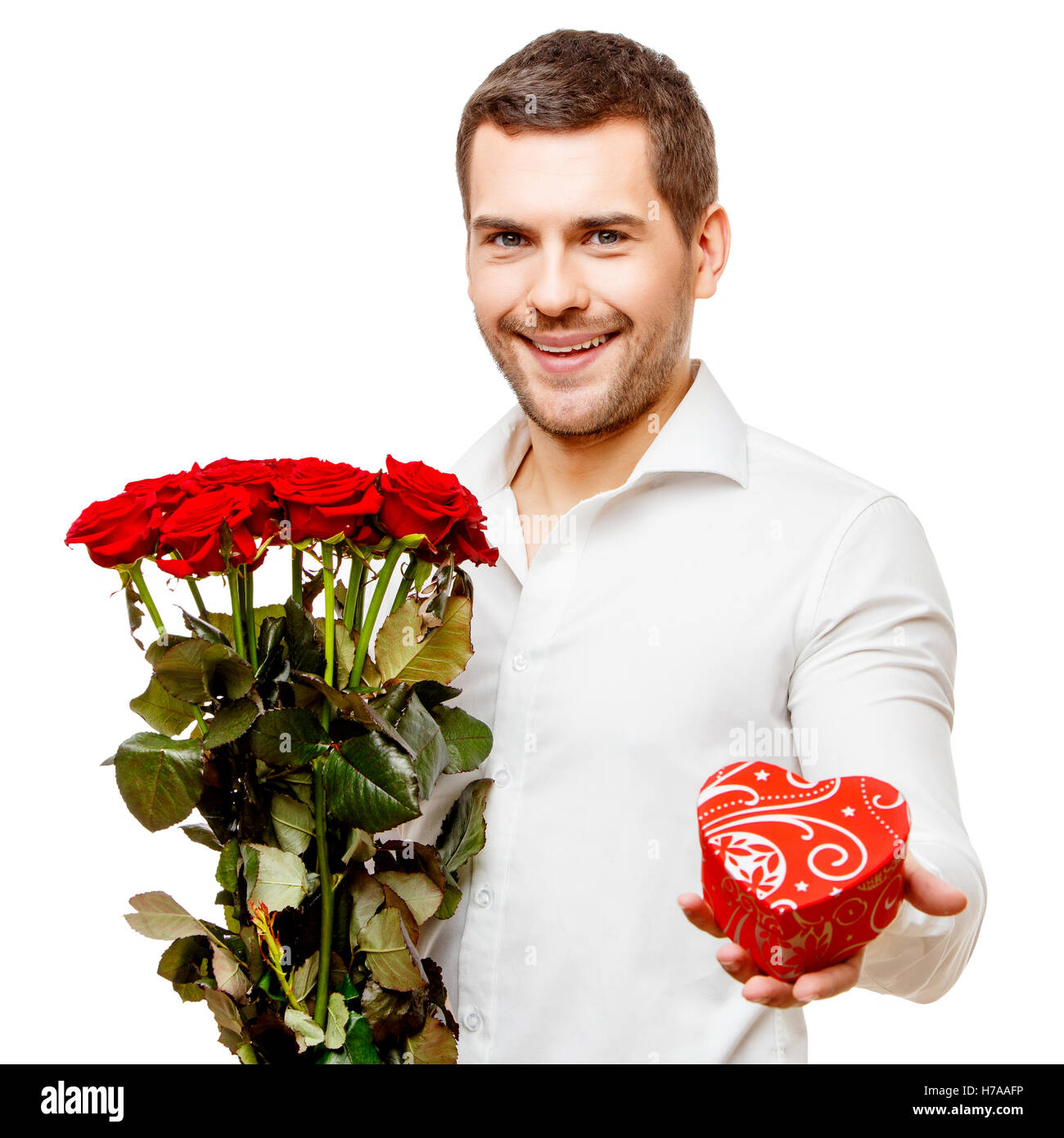 Young man carries heart shaped box and flowers Stock Photo - Alamy