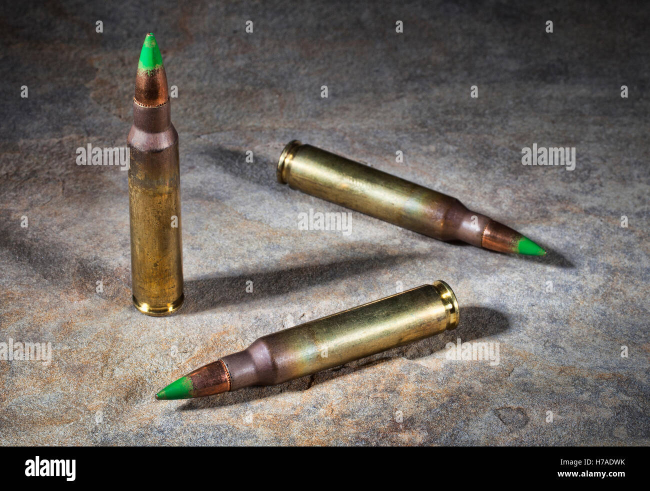 Rifle cartridges with green tipped bullets on a rock background Stock ...