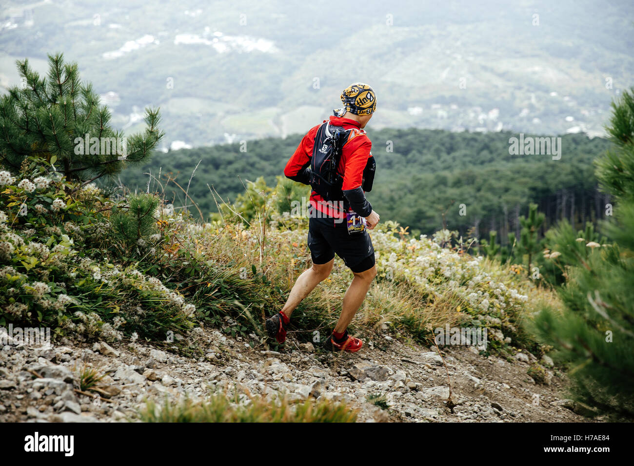 male athlete marathon runner running with mountains along trail during ...