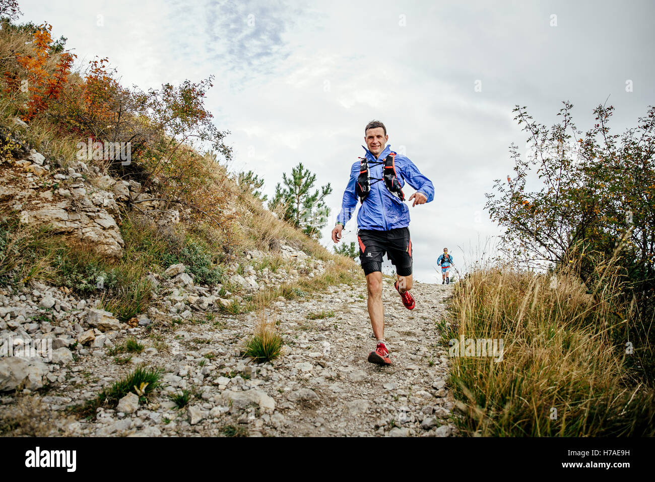 male runner of middle age runs on a mountain trail during Crimea ...
