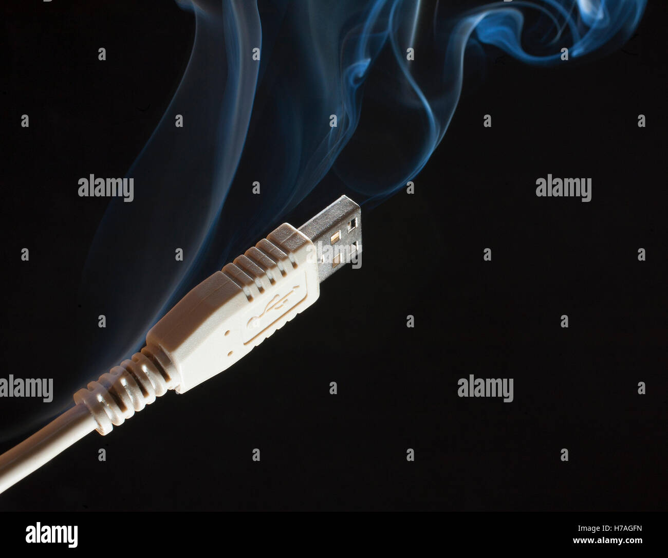 Computer connection and wire that is smoking on a black background ...