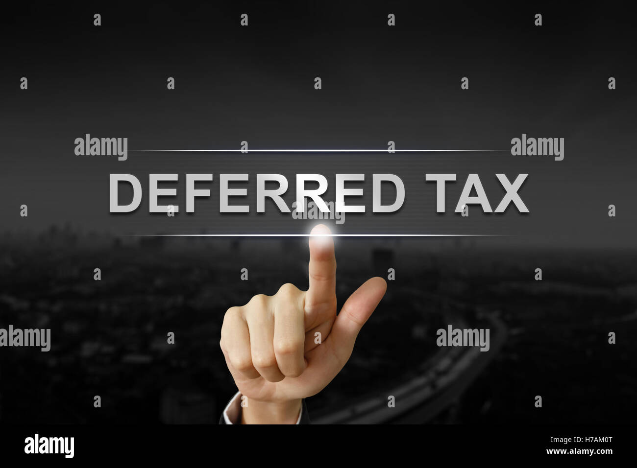 business hand clicking deferred tax button on black blurred background ...