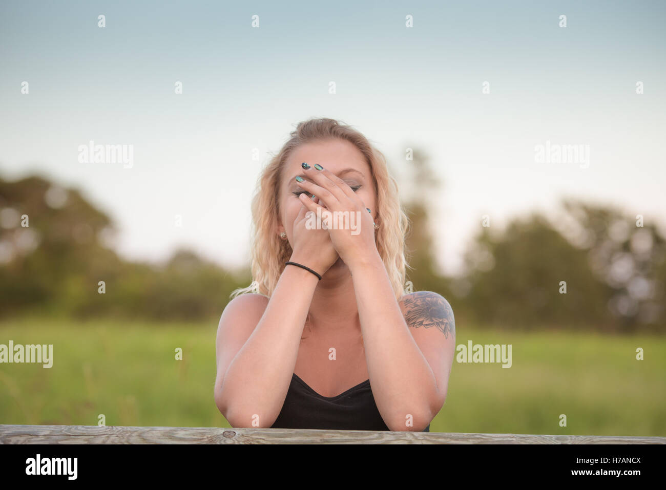 Blonde woman covering face with hands. Concept - embarrassed, laughing ...