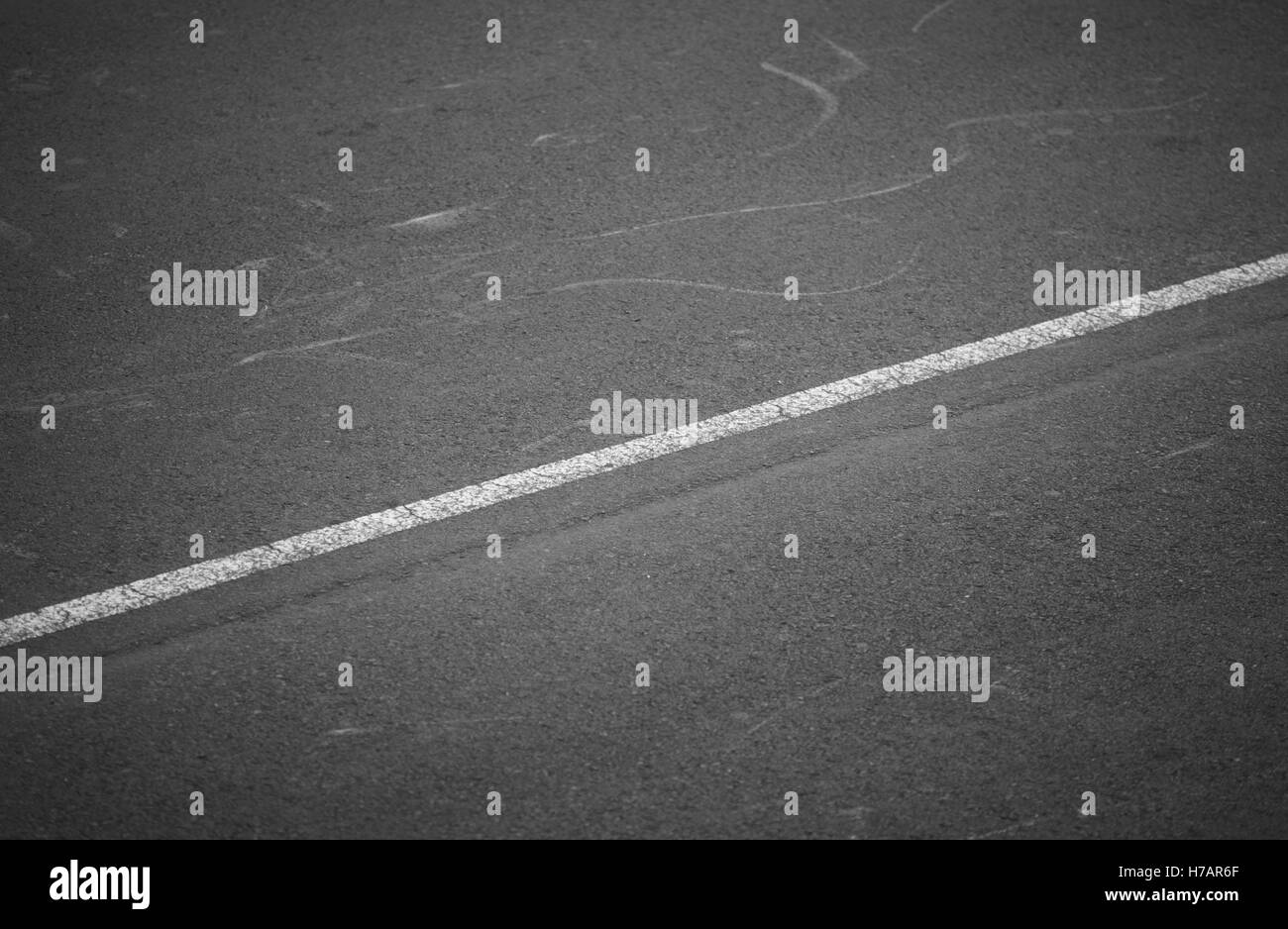 White line over an old asphalt street. Black and white. Horizontal ...