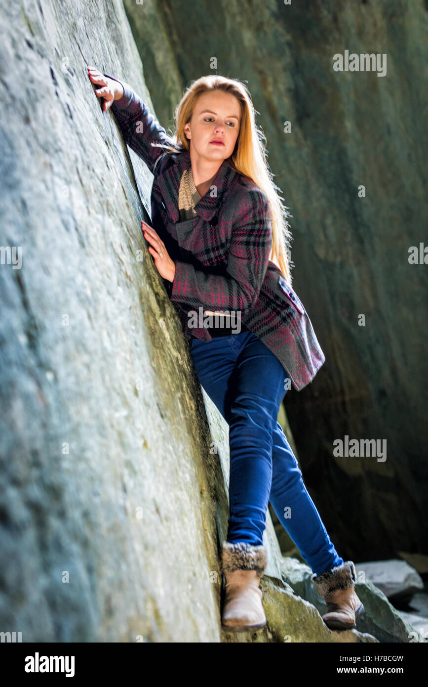 Woman clinging to cliff face Stock Photo - Alamy
