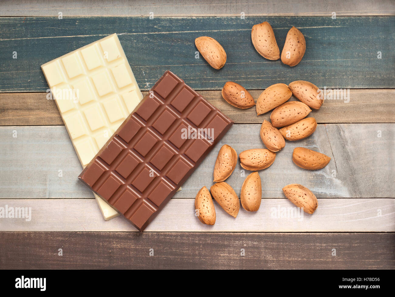 Close up of a bunch of raw almonds in their shells and bars of milk and ...