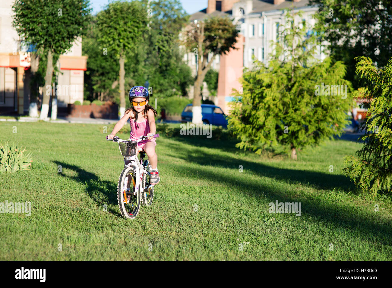 happy child girl riding bicycle in summer sunset in the park. Active ...