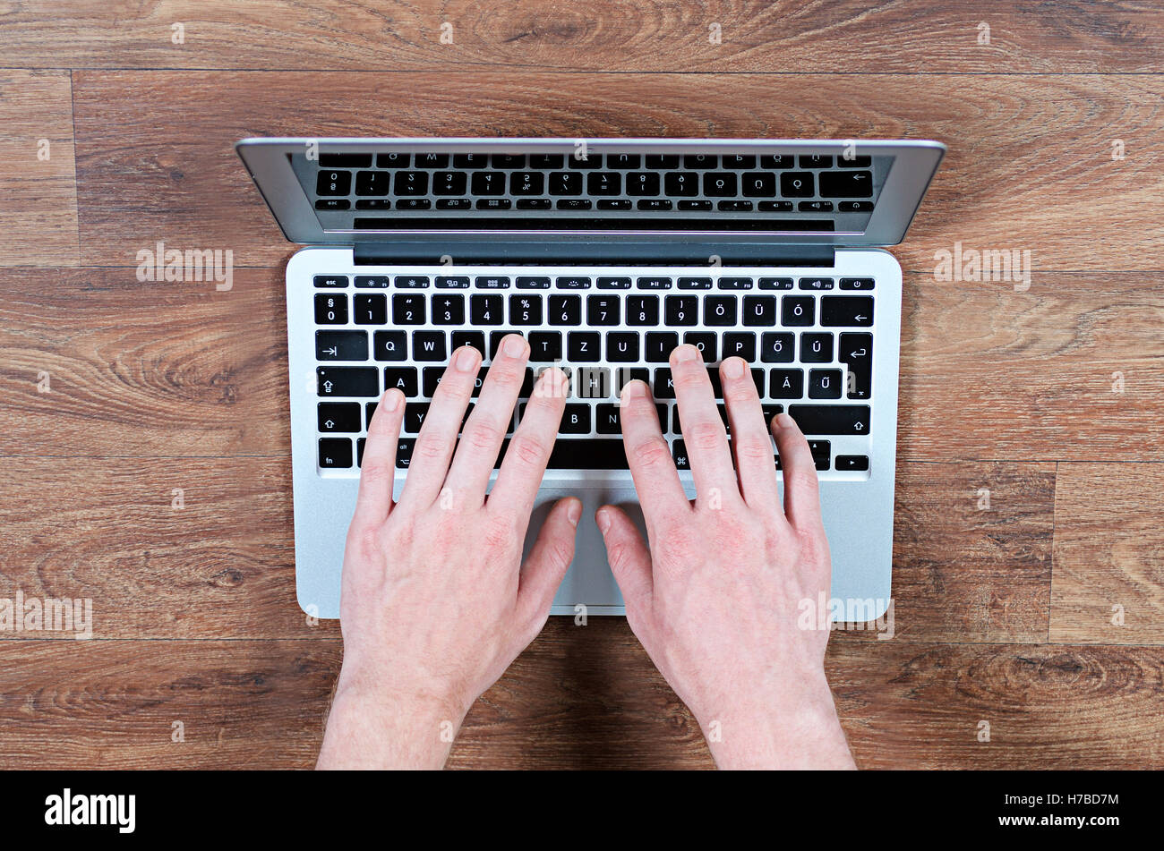 Young Adult Man Sitting on Floor with Hands on the Keyboard of a ...