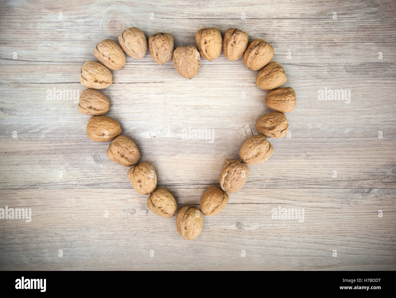 Heart shape made of walnuts on wooden background. Healthy eating ...