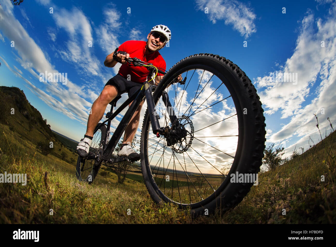 Sportive man with bicycle at sunset Stock Photo - Alamy