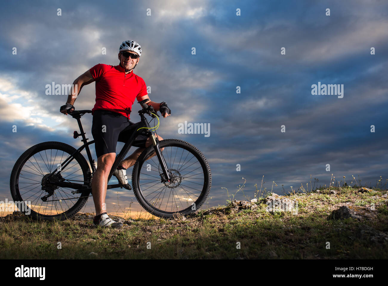 Sportive man with bicycle at sunset Stock Photo - Alamy