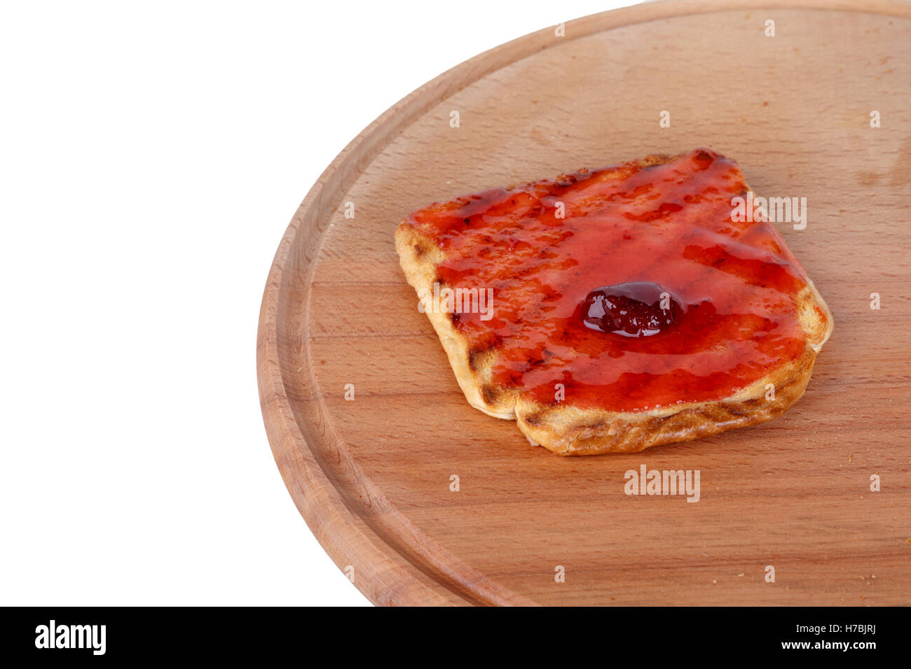 Close up view of burnt toasted bread with jam on wooden board, isolated ...