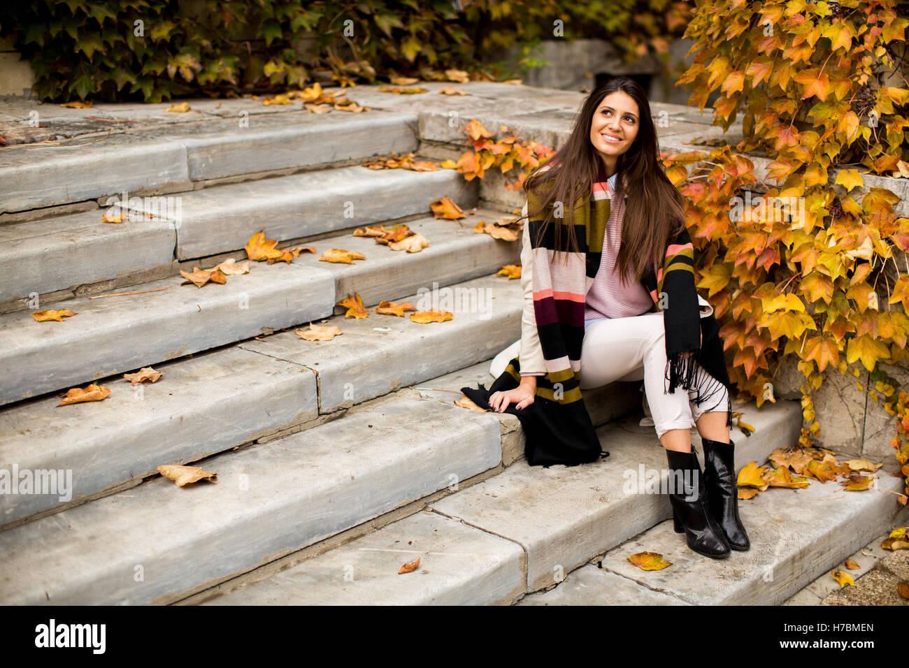 Young woman sitting on the steps outside in autumn day Stock Photo - Alamy