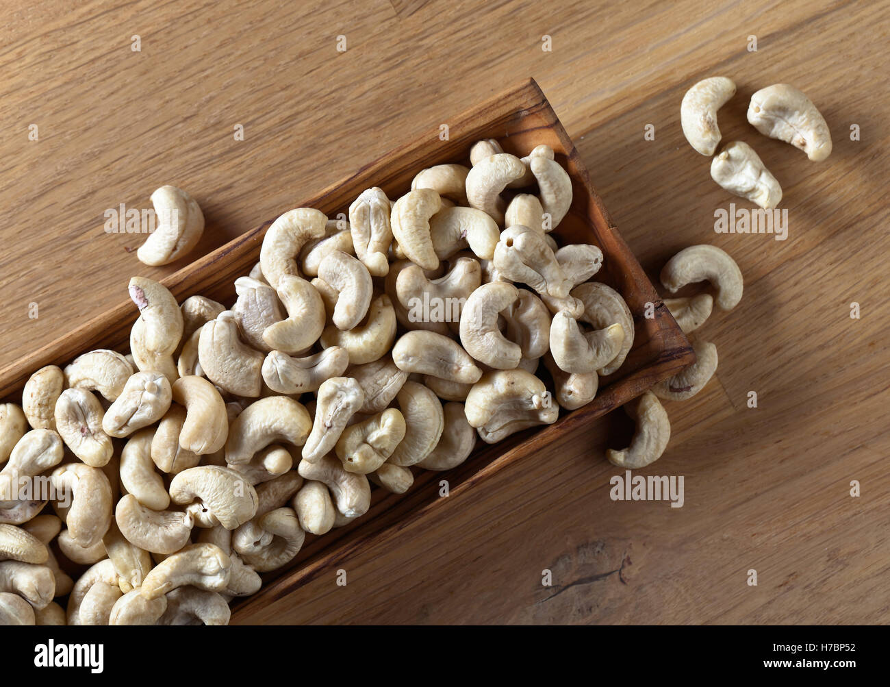 Cashews in old wooden dish on a kitchen table Stock Photo - Alamy