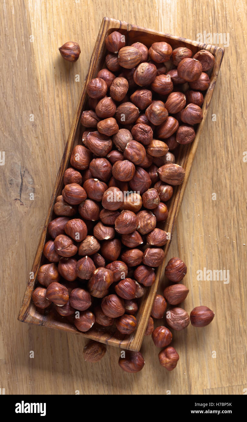 Hazelnuts in old wooden dish on a kitchen table Stock Photo - Alamy