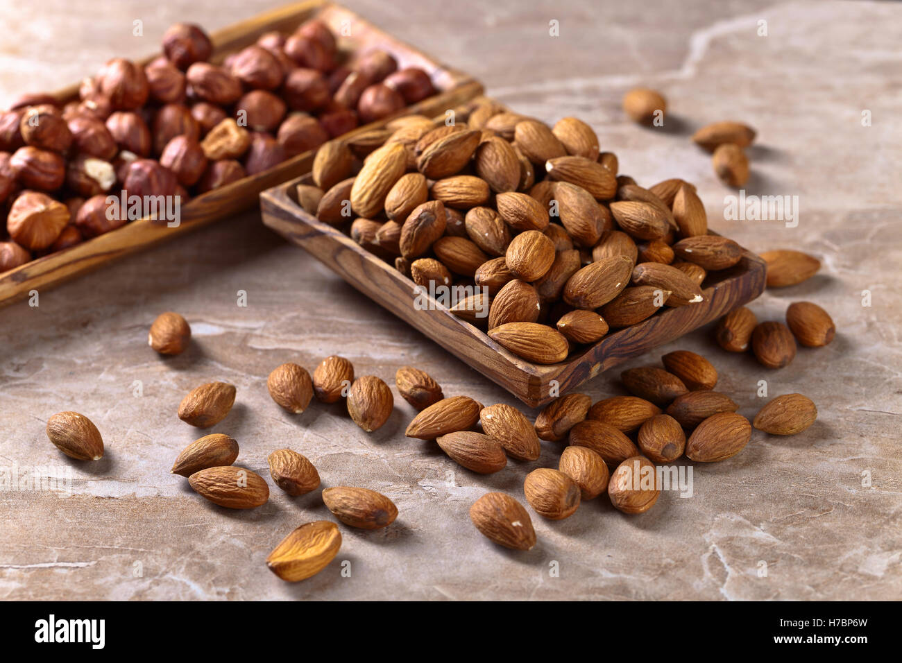 Almonds in old wooden dish on a kitchen table Stock Photo - Alamy