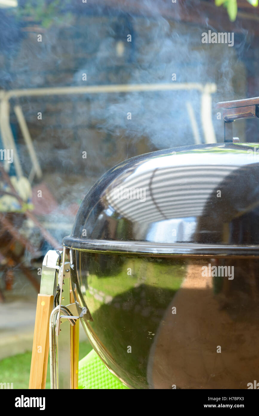 Smoke go out from a closed barbecue during pulled pork grill Stock ...