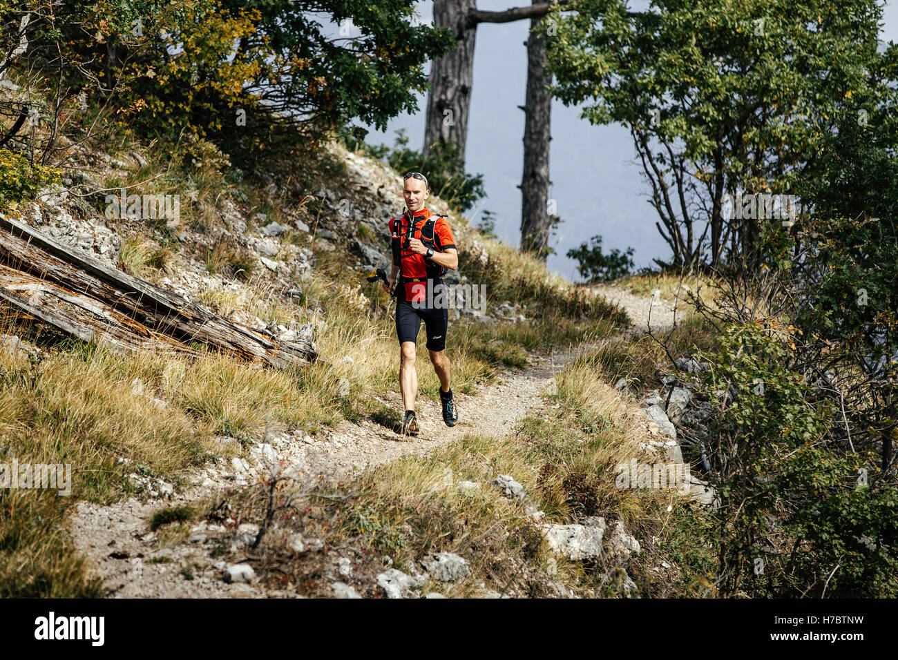 young male runner running with walking sticks during Crimea mountain ...