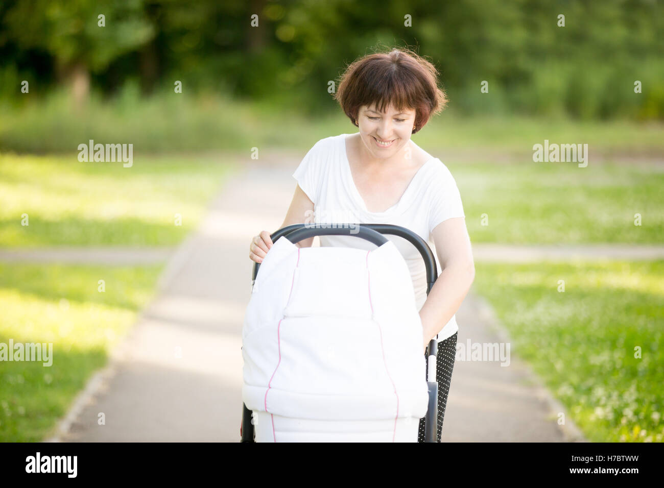 Grandmother walking with a baby stroller in park Stock Photo - Alamy