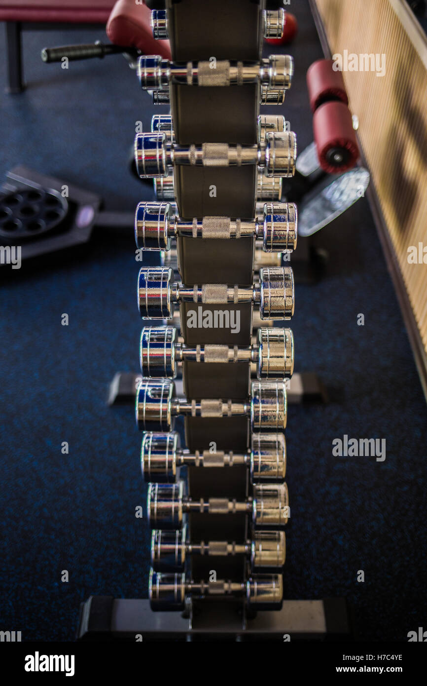 Sport Background. Rack of dumbbells in health club. Shelf with metal on ...