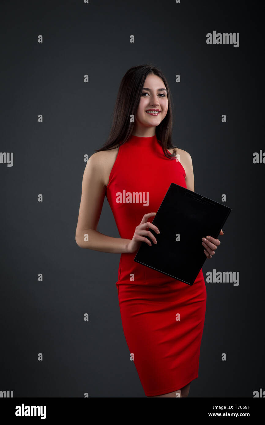 Beautiful office worker in red dress holding black folder Stock Photo ...
