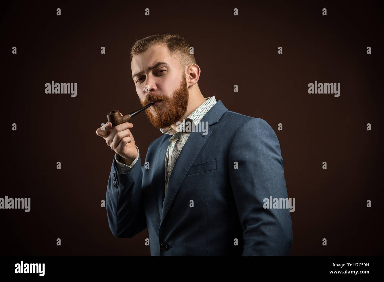 Elegant man with beard holding smoking pipe Stock Photo - Alamy