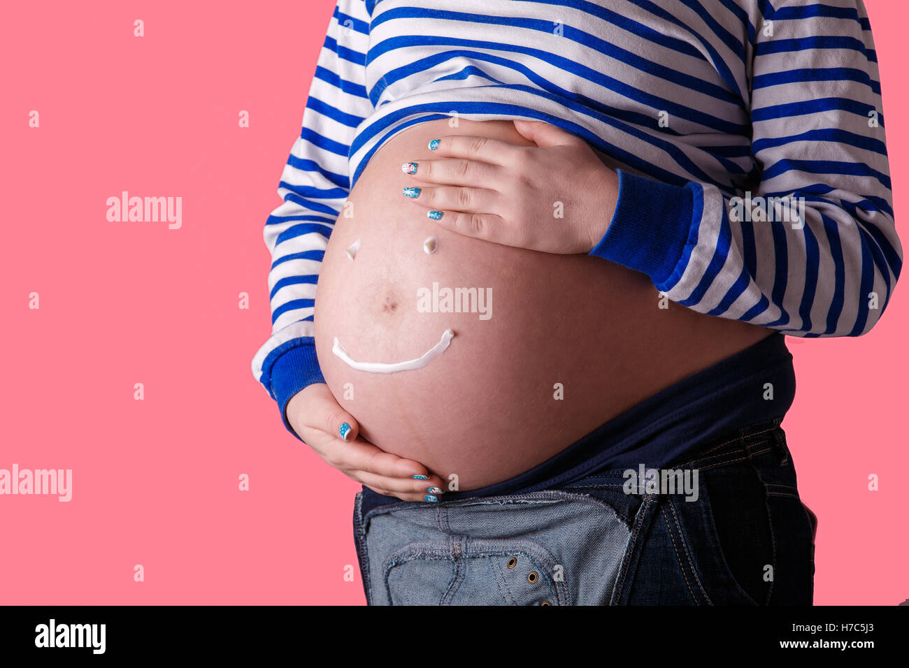 Pregnant woman writing 'smiley' word on her belly. Trendy Pink ...