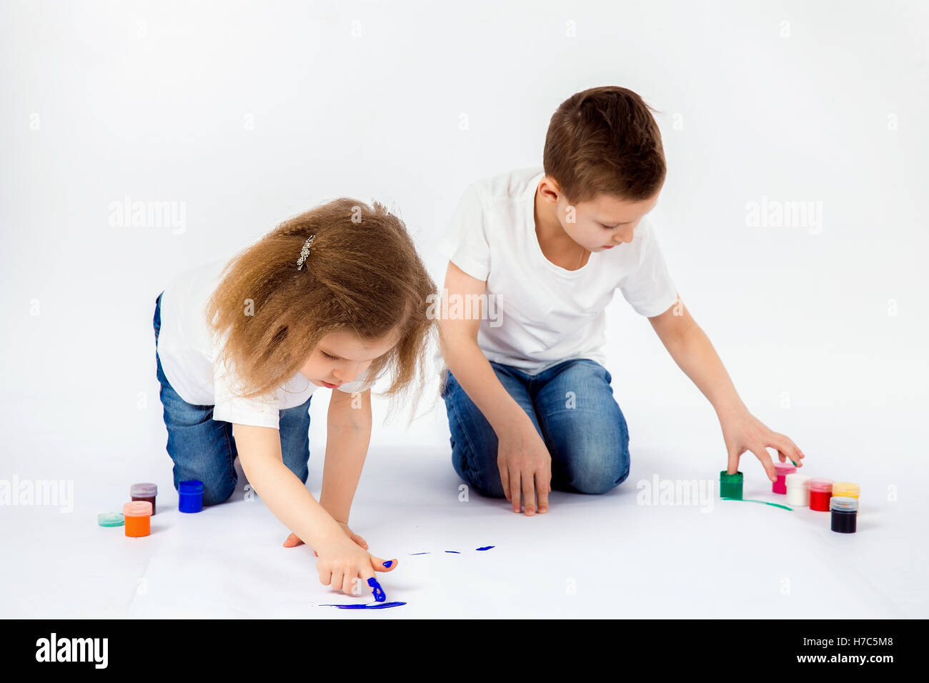 Two pretty children playing with paints Stock Photo - Alamy