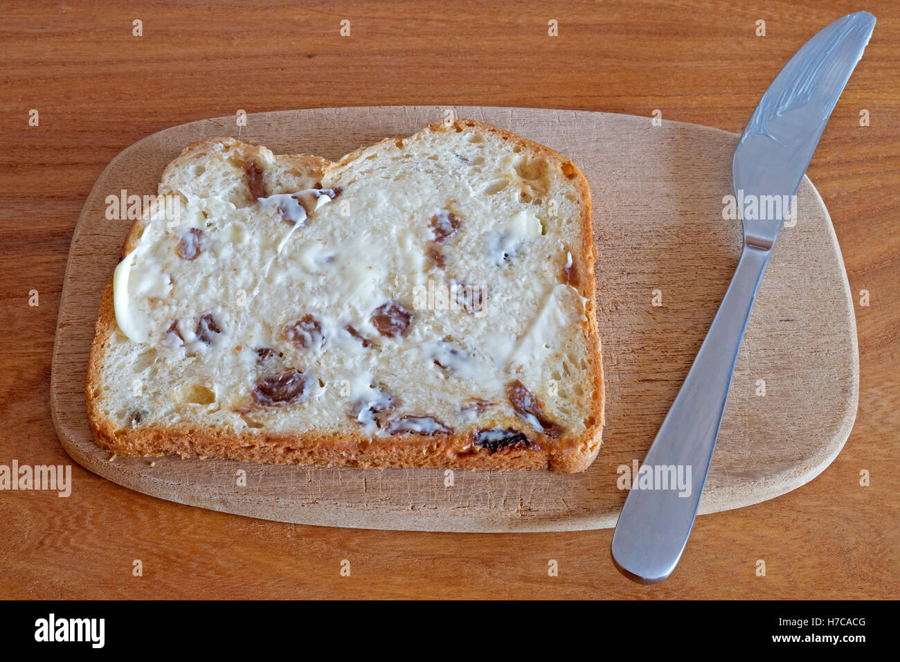Slice of buttered fruit bread Stock Photo - Alamy