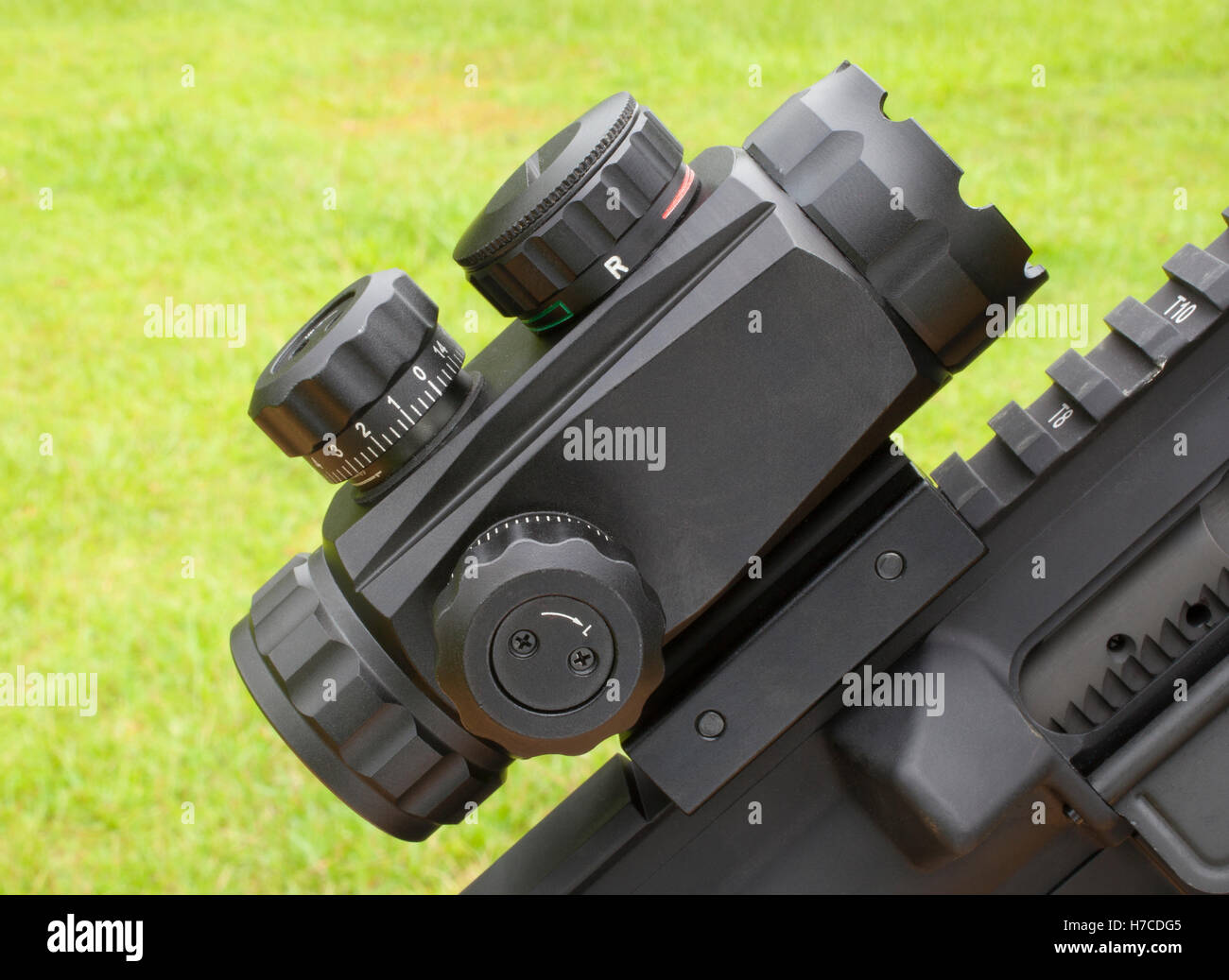 Small rifle scope mounted on a modern sporting rifle with a green ...
