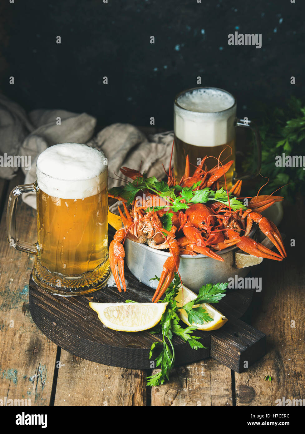 Two pints of wheat beer and boiled crayfish with lemon and parsley on ...