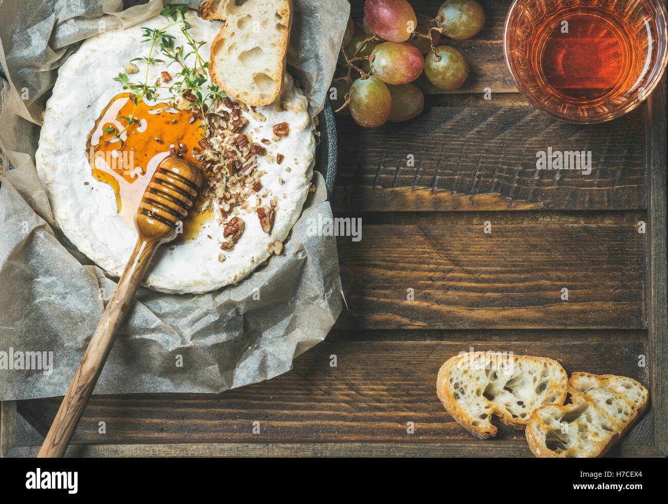 Homemade camembert cheese with honey, herbs and nuts, green grapes ...